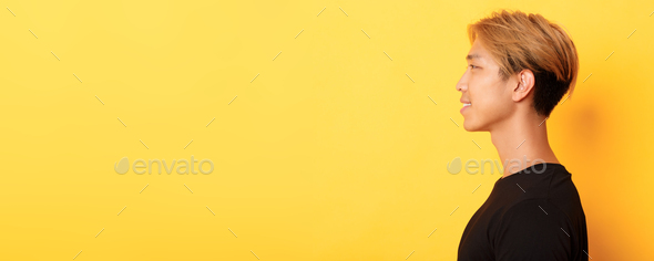 Profile of stylish handsome asian guy with fair hair looking left and ...