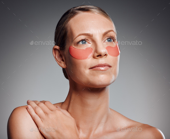 Beautiful mature woman posing with under eye patch in studio against a ...