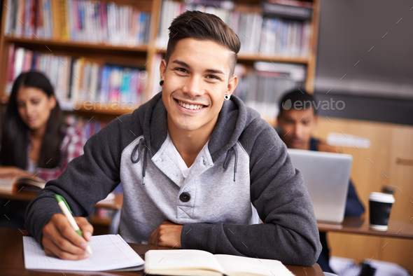 Cropped portrait of a handsome young student working diligently in his ...