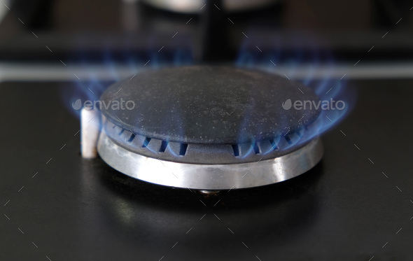 Close-up blue flames of fire on a gas burner in the kitchen for cooking ...