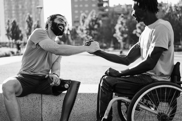 Multiethnic friends with disability greeting each other at park city ...