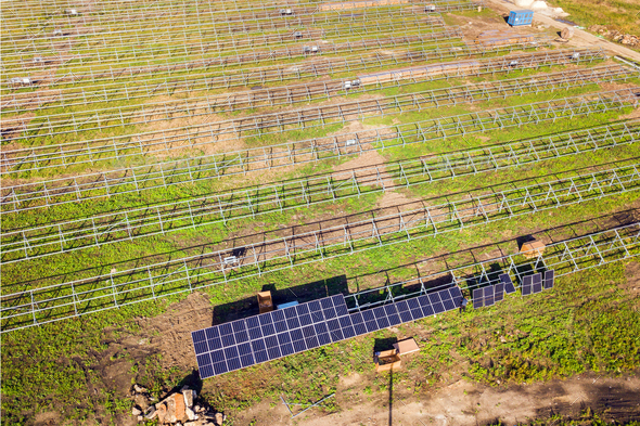 Aerial view of solar power plant under construction on green field ...