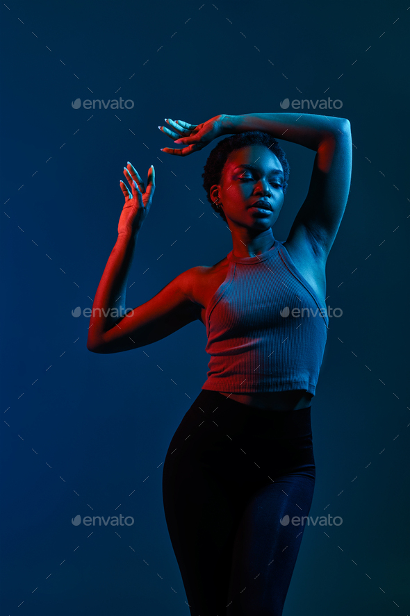 Woman moving gracefully over dark studio background Stock Photo by ...