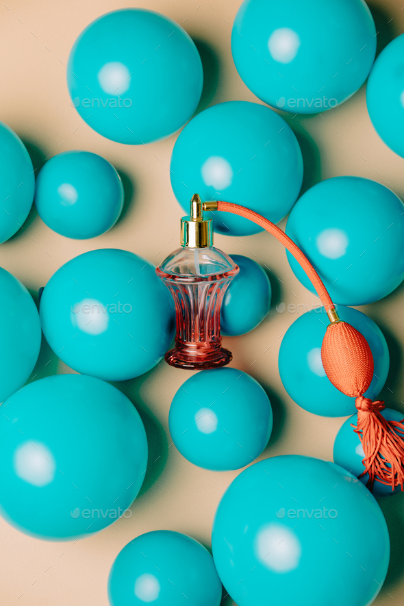 Stylish perfume bottle and blue balloons around Stock Photo by Masson-Simon
