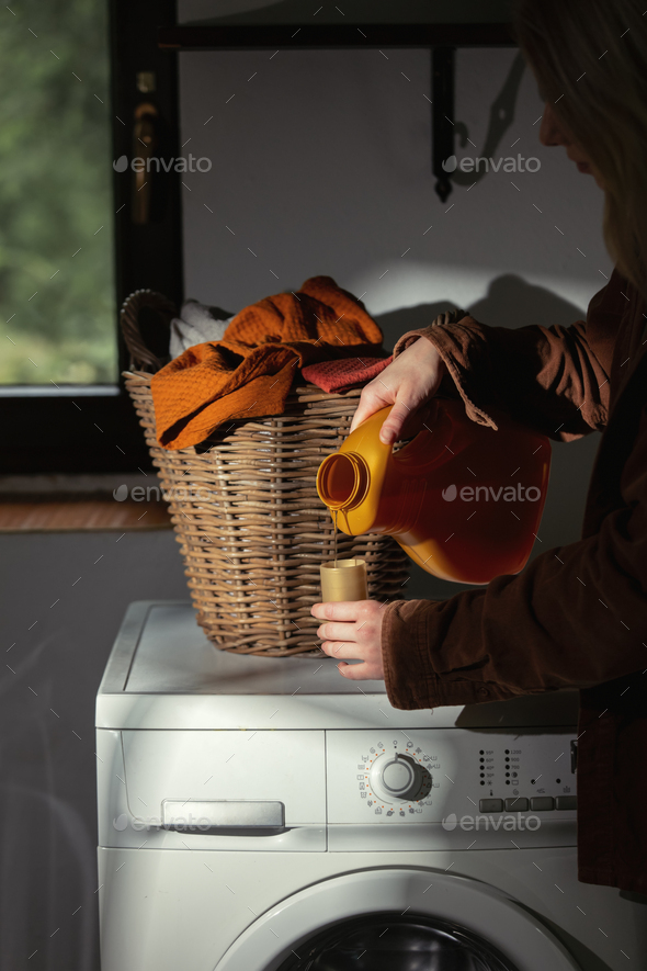 Female next to washing machine and clothes in home laundry Stock Photo ...