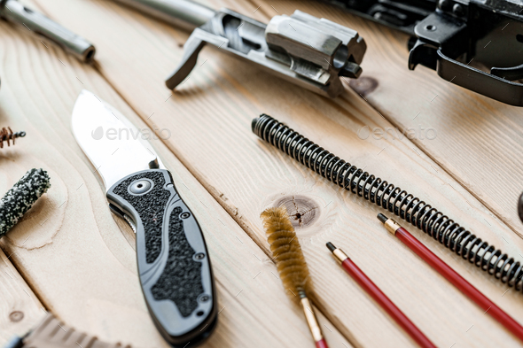 Disassembled rifle with cleaning tools on table of weapons workshop ...