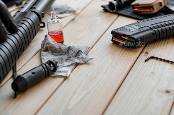 Disassembled rifle with cleaning tools on table of weapons workshop ...