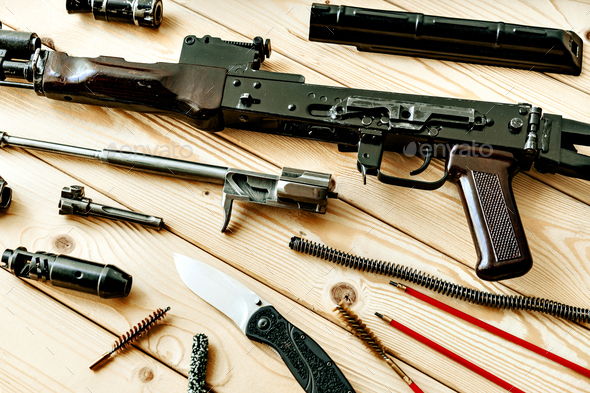 Disassembled rifle with cleaning tools on table of weapons workshop ...