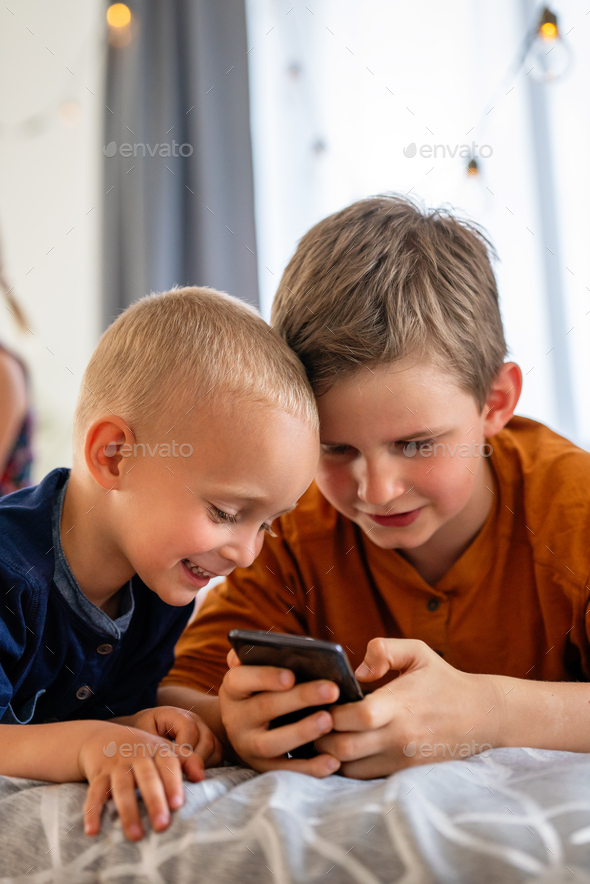 Portrait of happy children using digital devices and having fun ...