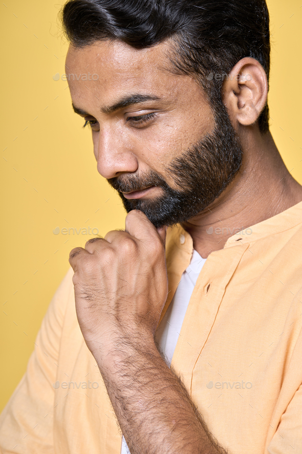 Smiling thoughtful indian man thinking isolated on yellow. Vertical ...