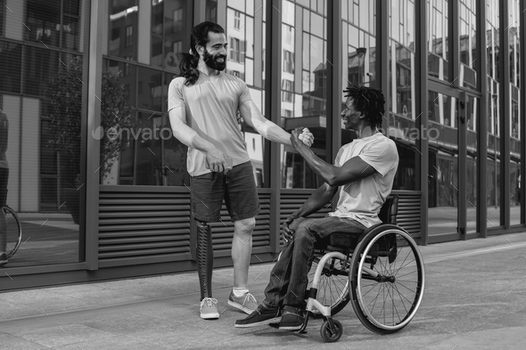 Multiracial people with physical disabilities greeting each other ...