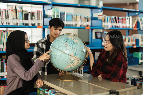 Students learning geography using globe at the classroom Stock Photo by ...