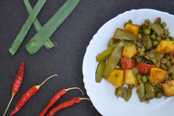 Flat lay of matar paneer mix veg recipe (Indian food) and red chillies ...