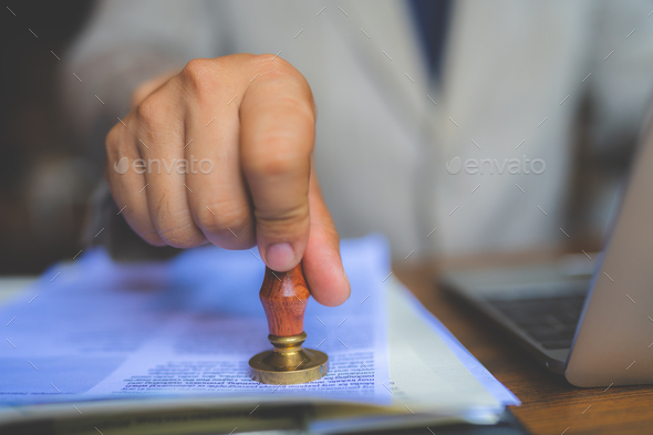 hand stamping with passed and approved stamp on certificate document ...
