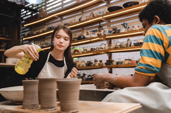 Beautiful young woman holding pottery instrument for scraping ...