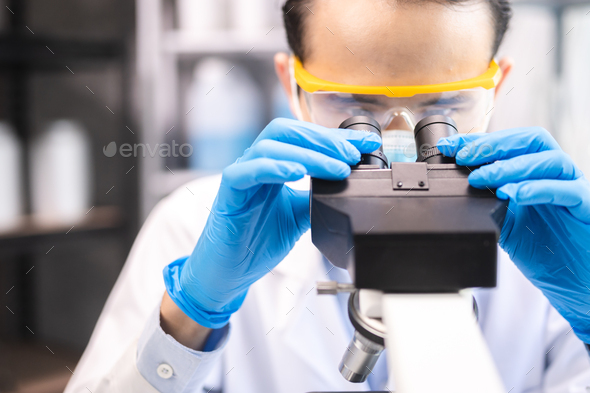 professional research scientist using microscope in science chemistry ...