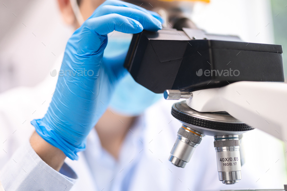 professional research scientist using microscope in science chemistry ...