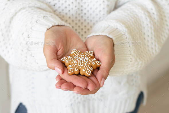 Christmas shortbread snowflakes. Women's hands hold traditional New ...