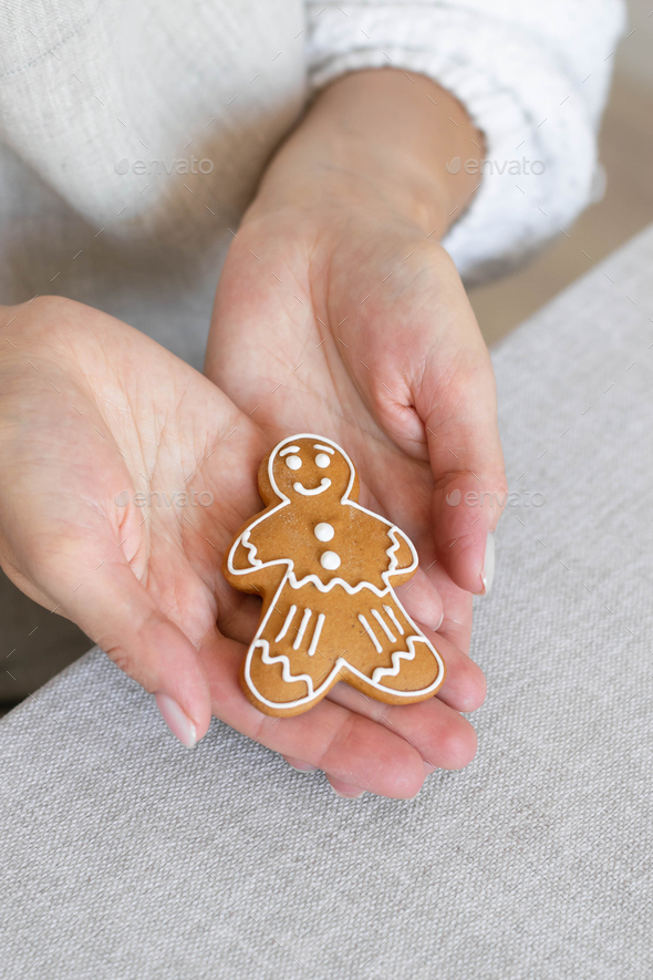 Christmas shortbread man. Women's hands hold a traditional New Year's ...