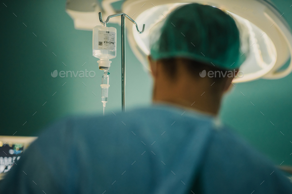 Doctor operating patient in surgical room at hospital - Focus on ...