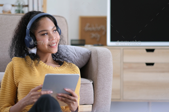 Photo of beautiful dark skin wavy lady homey mood holding digital ...