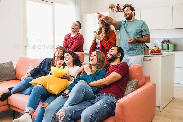 A group of friends have fun watching funny content on Television ...