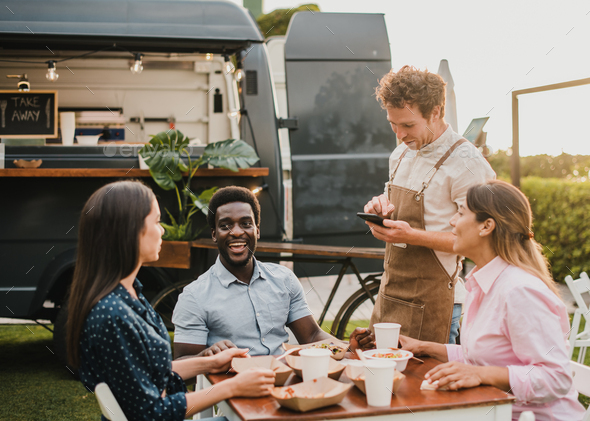 Multiracial people ordering food at food truck outdoor - Focus on ...