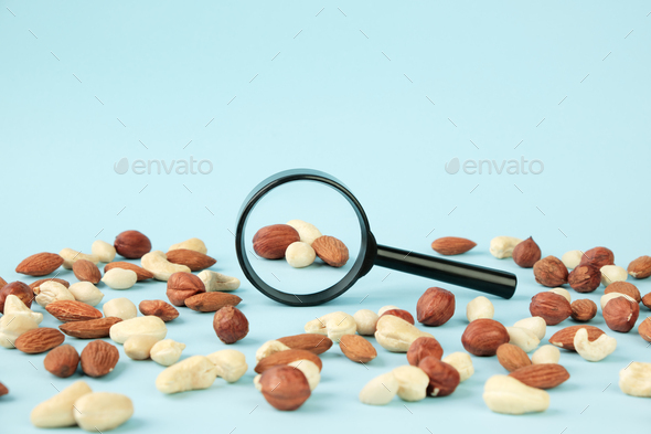Nuts under a magnifying glass. Food quality control. Stock Photo by ...