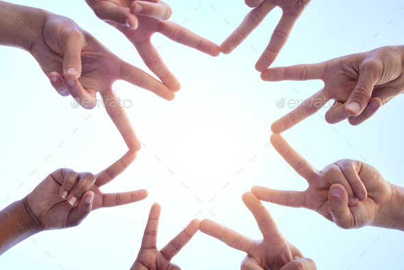 Shot of a group of people forming star shapes with their hands in a ...