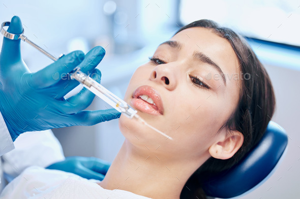 That is one big needle. Shot of a dental patient about to receive an ...