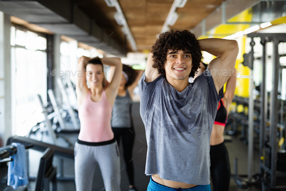 Group of fit people working out in a gym. Multiracial friends ...