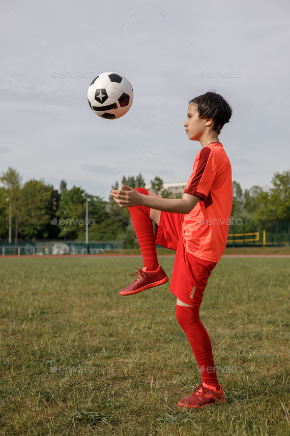 Girl kicking the soccer ball with her knee Stock Photo by AmparoGV