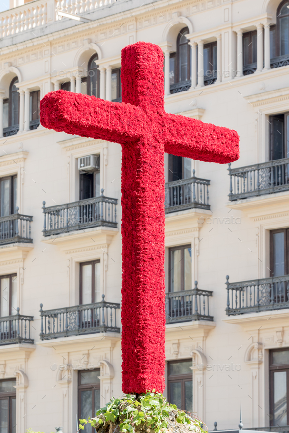 Christian cross covered with red flowers Stock Photo by mazzafabio