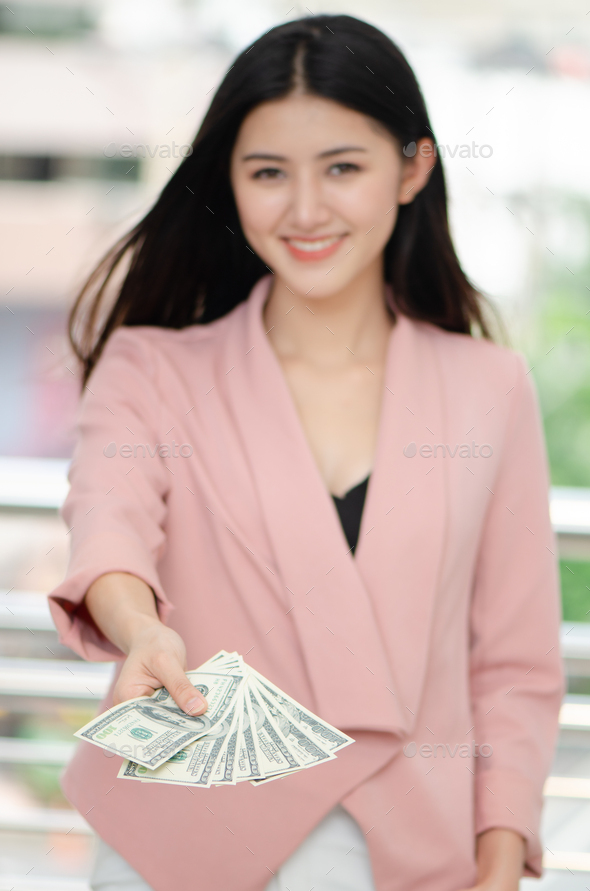 Beauitful young asian woman give money Stock Photo by mrzphotoproducer