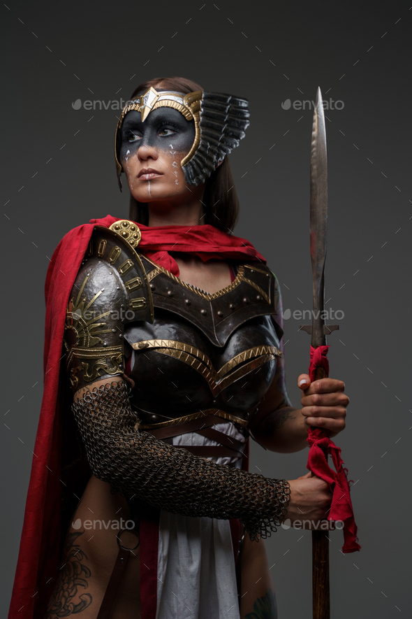 Female warrior with spear dressed in red cloak and armor Stock Photo by fxquadro