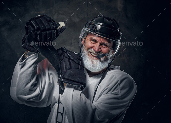 Cheerful old man hockey player with hockey stick Stock Photo by fxquadro