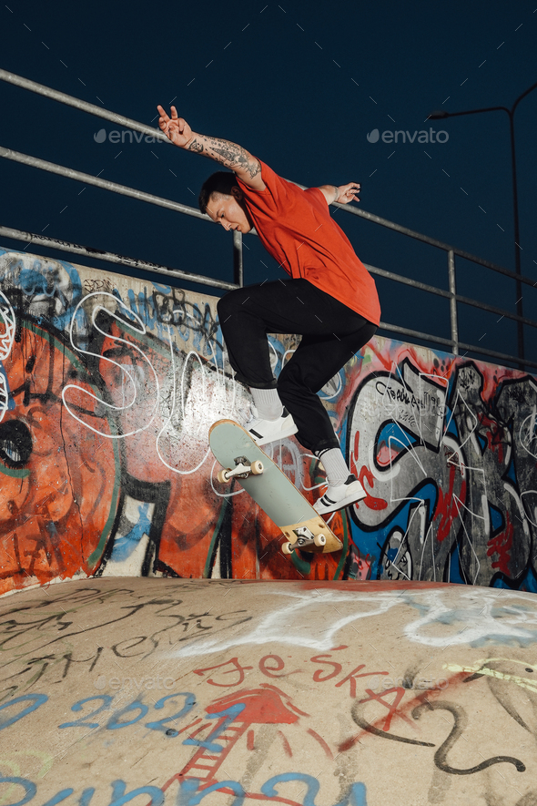 Skilled guy skateboarding at skate park at night time Stock Photo by ...