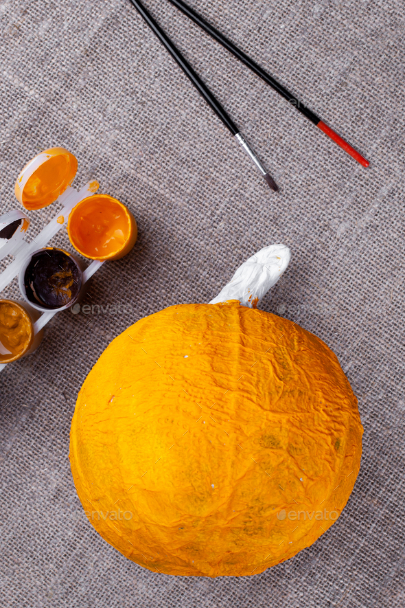 orange homemade pumpkin made of papier mache, brushes, paint on burlap ...
