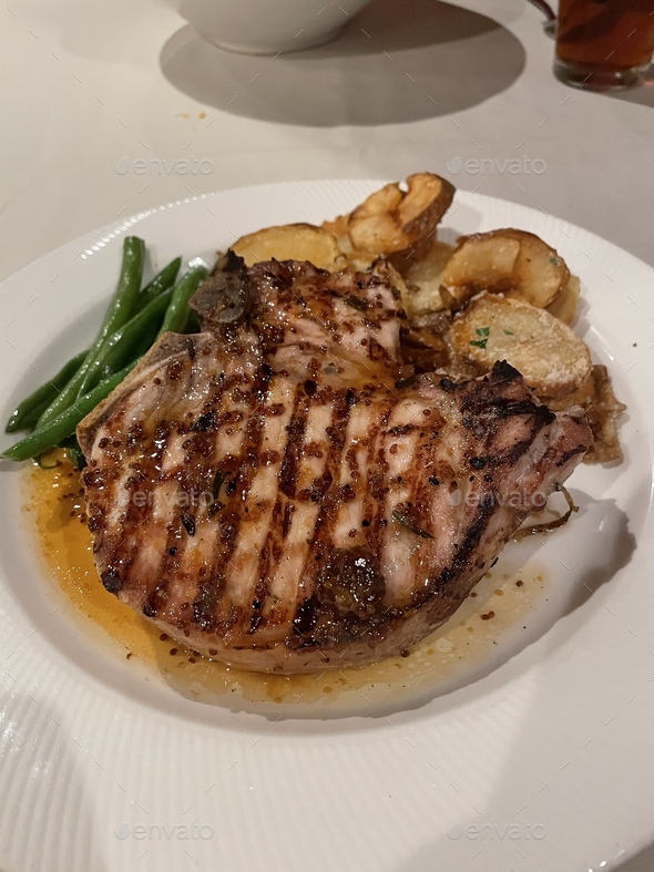Giant pork chop with fries and green beans Stock Photo by Adventureawaits10