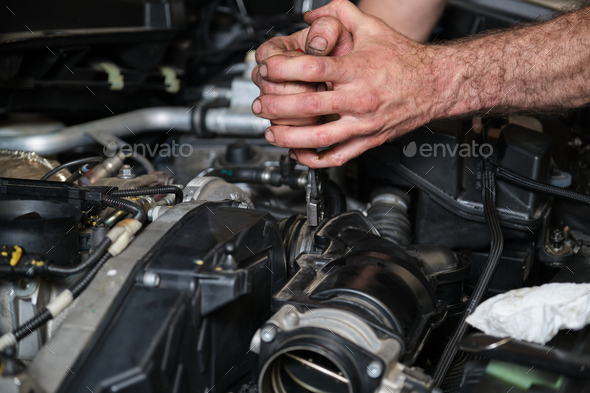Car mechanic hands replacing engine throttle body. Stock Photo by Ladanifer