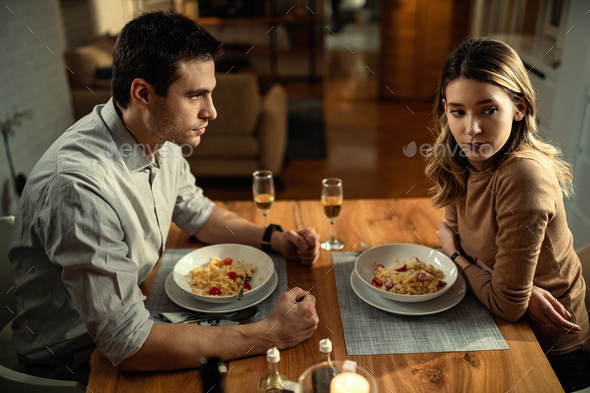 Distraught couple having an argument at dining table. Stock Photo by ...