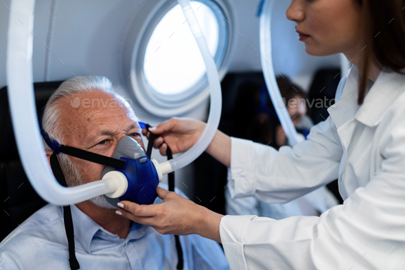 Senior man receiving oxygen therapy in hyperbaric chamber at clinic ...