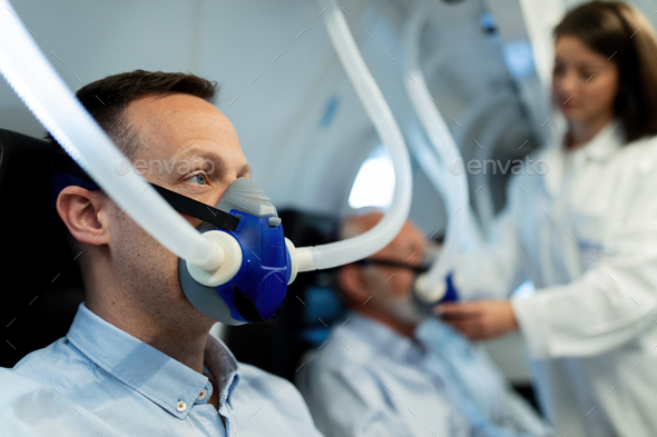 Male patient receiving oxygen therapy in hyperbaric chamber. Stock ...
