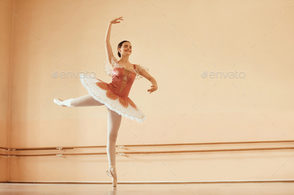 Full length of smiling ballerina dancing in ballet studio. Stock Photo ...