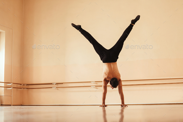Back view of male ballet dancer doing handstand at dance studio. Stock ...