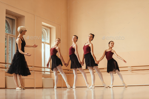Group of ballerinas holding hands while dancing on ballet class. Stock ...