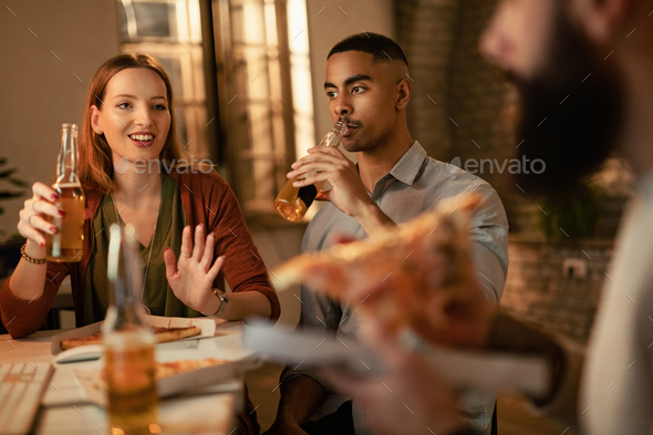 Young happy colleagues drinking beer and communicating on lunch break ...