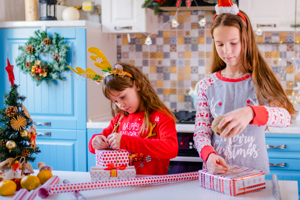 process of packing Christmas gifts, girls 7 years old and 10 years old ...
