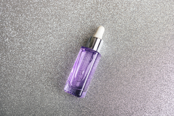 Cosmetic purple serum bottle on silver background. Skincare, spa and ...