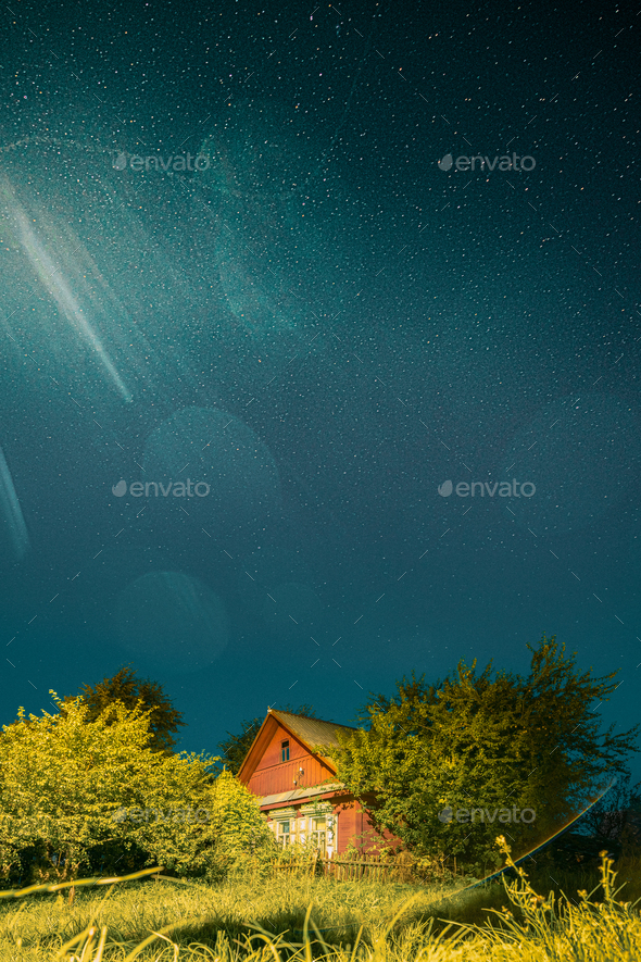 Night sky over house in village. Night starry sky above house with ...